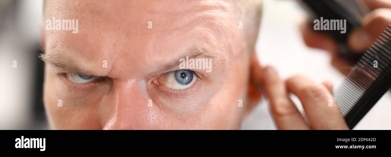 Portrait of pensive man who is being cut with a machine Stock Photo - Alamy