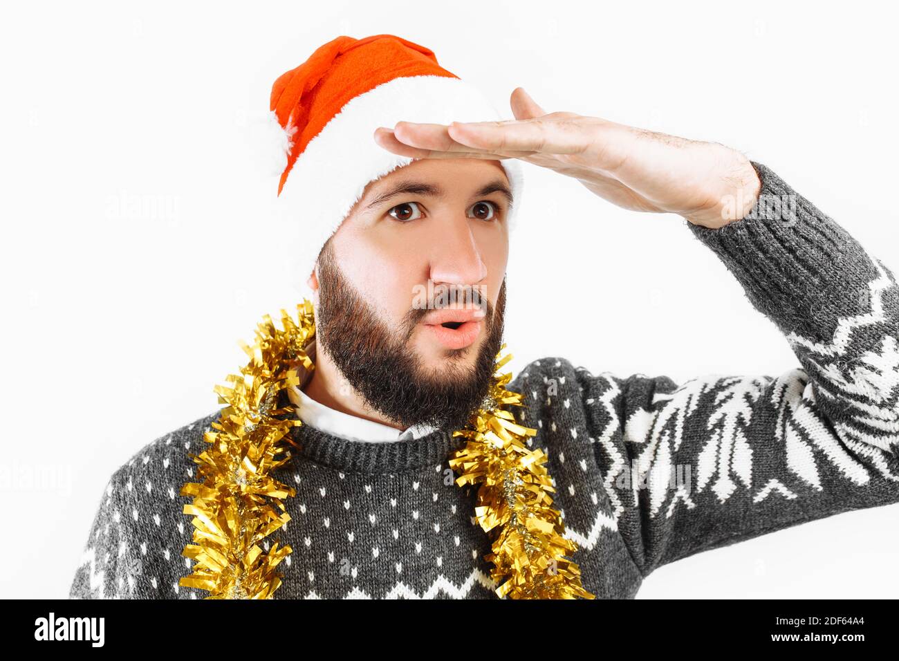 Young Man With A Beard A Man In A Santa Claus Hat Looks Into The