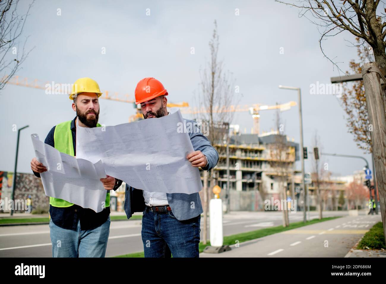 Architect and construction worker having work meeting at construction ...