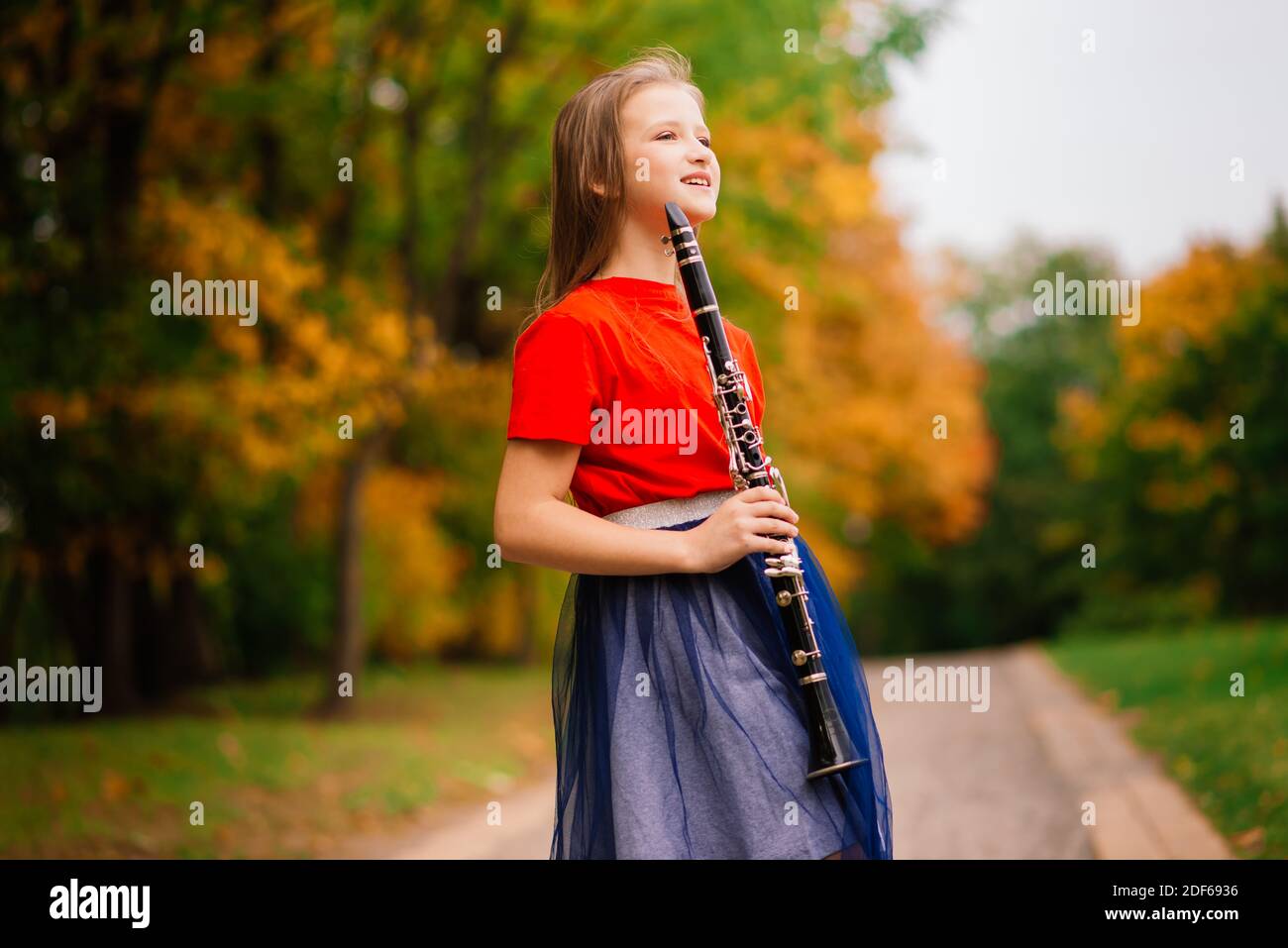 Young attractive girl playing clarinet in fall park Stock Photo - Alamy