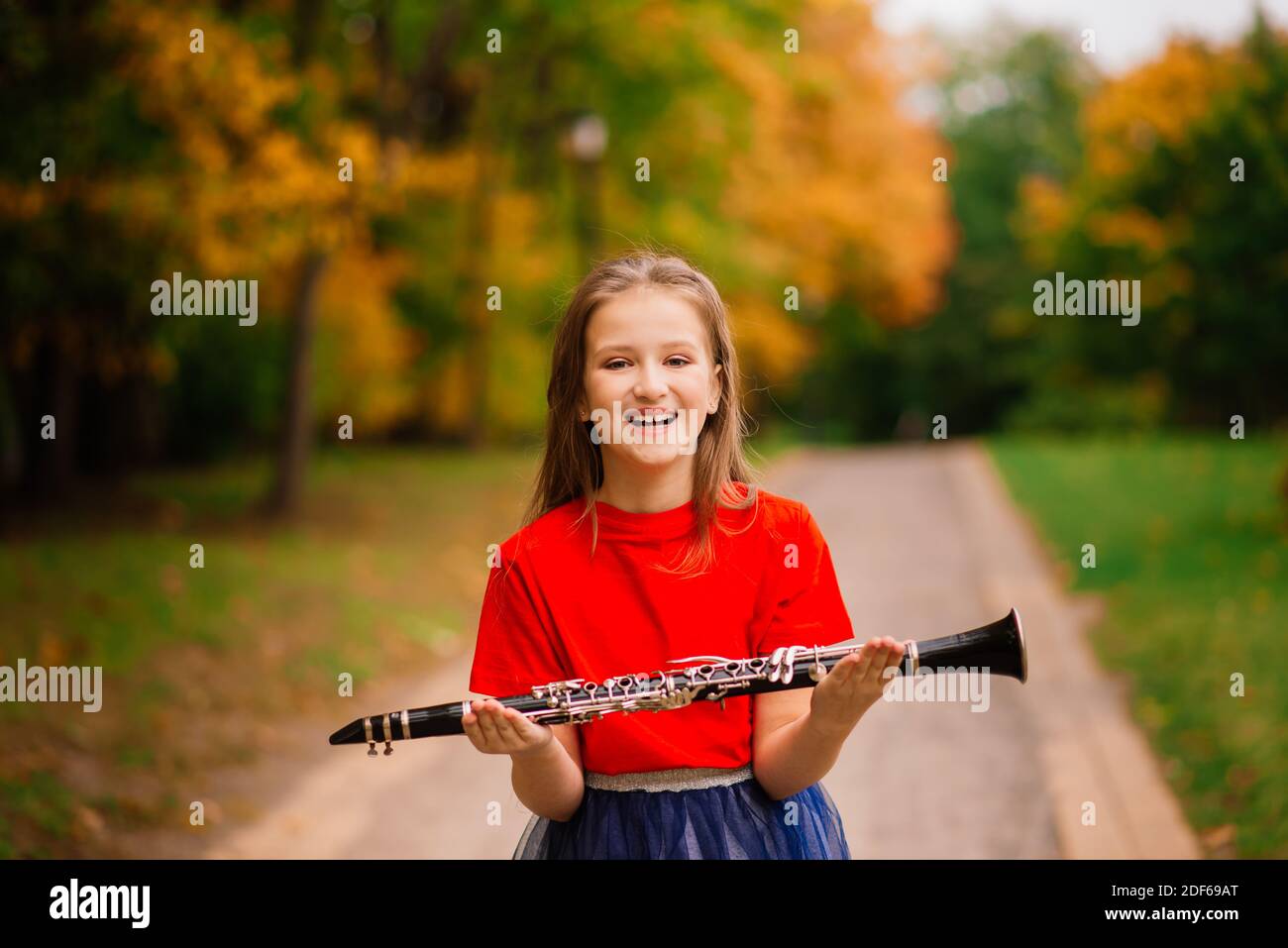 Young attractive girl playing clarinet in fall park Stock Photo - Alamy