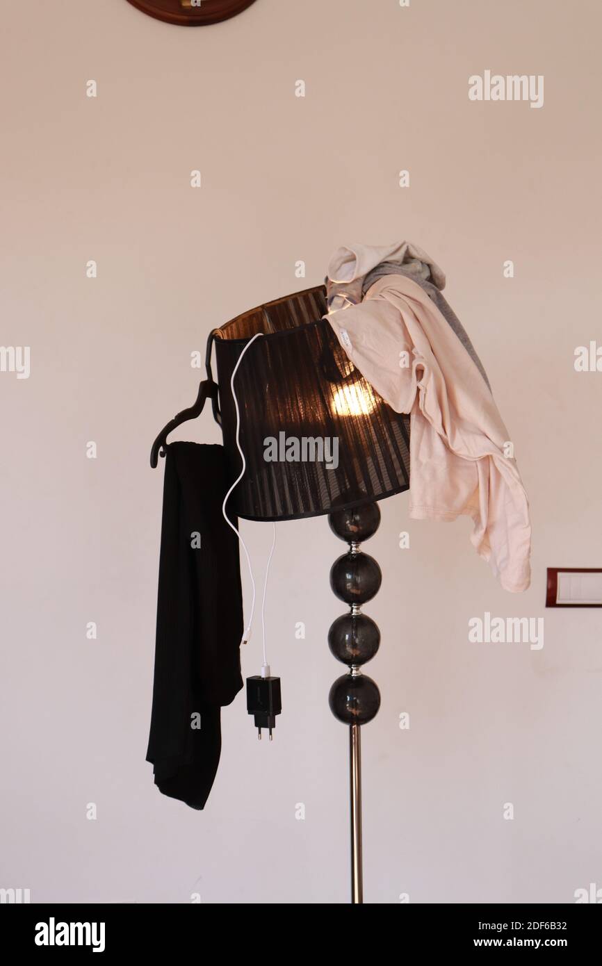 Clothes on the lamp, wardrobe mess Stock Photo - Alamy