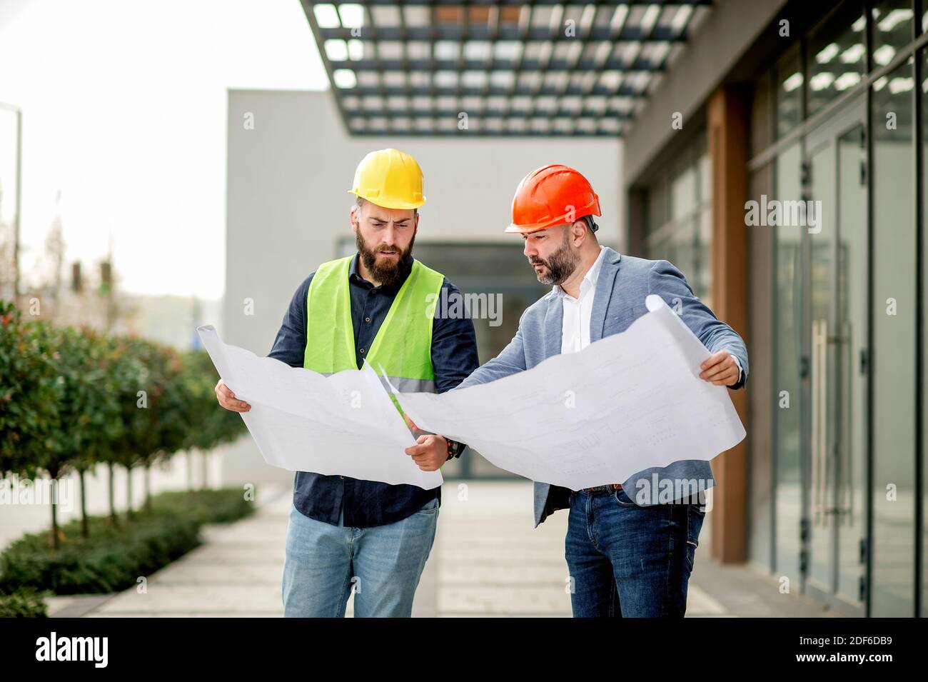 Two architects examining a blueprint and working on a building project ...