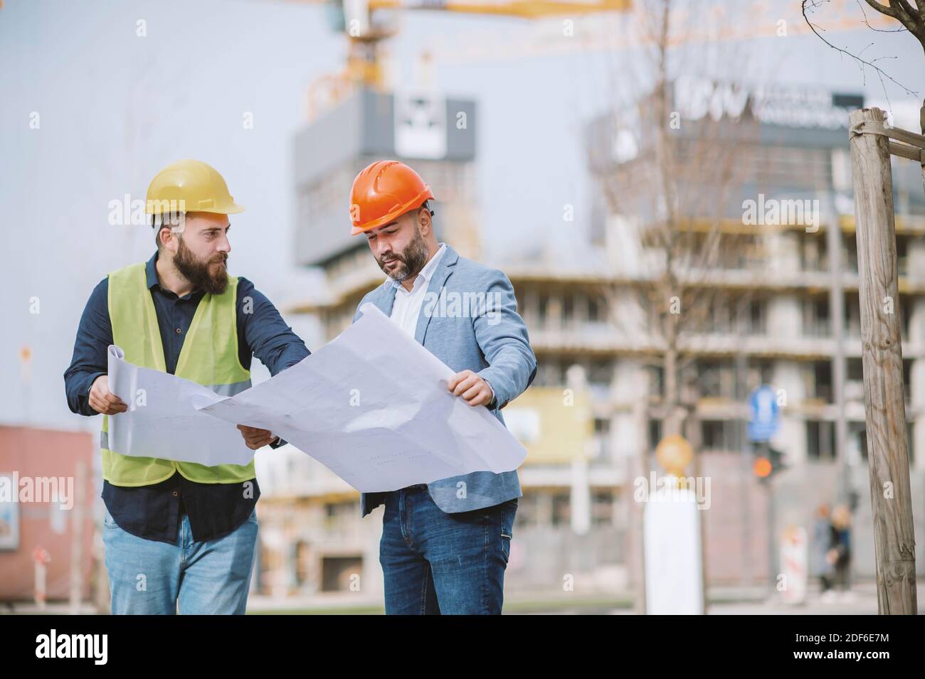 Architect and construction worker having work meeting at construction ...