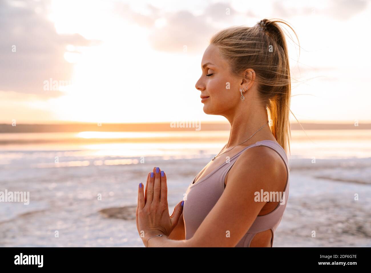 Young caucasian woman meditating with palms together while practicing ...