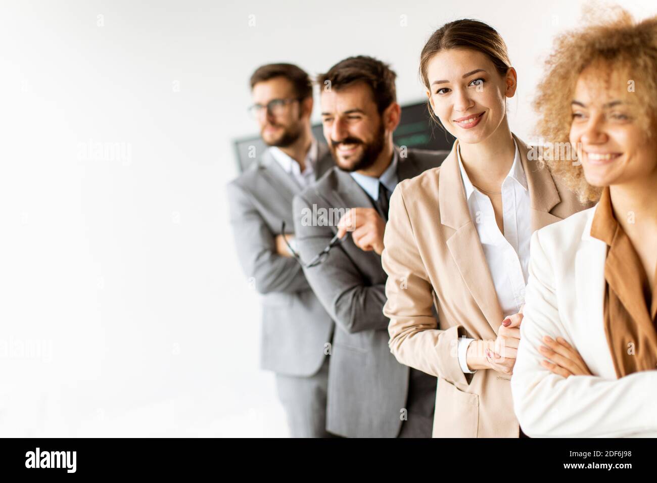 Smiling young business woman standing with group of corporate ...