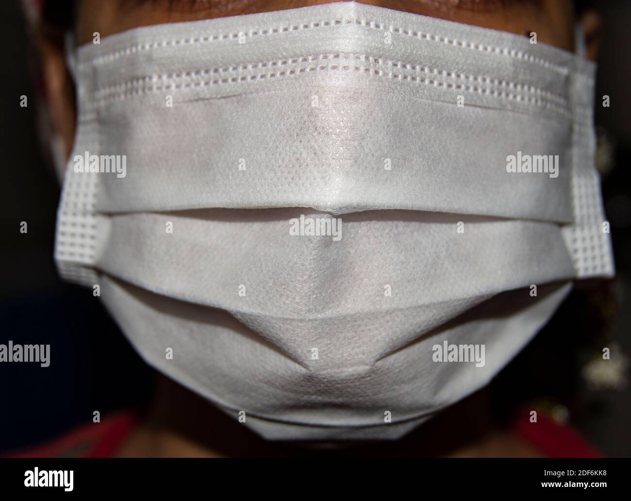 A woman standing with smoky glasses and a mask on sky background ...