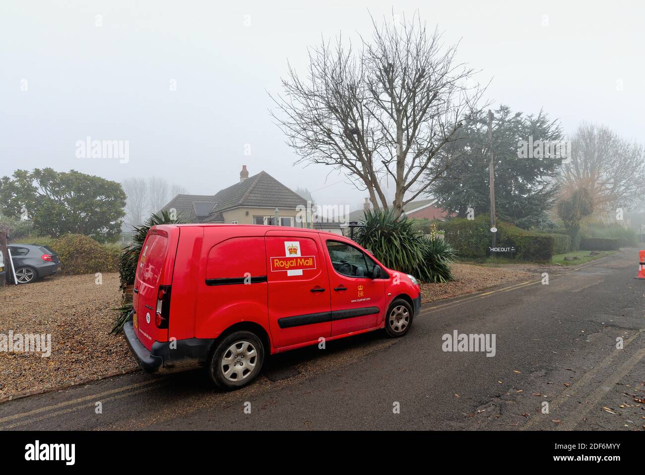 A small red Royal Mail delivery van parked on a country road in ...