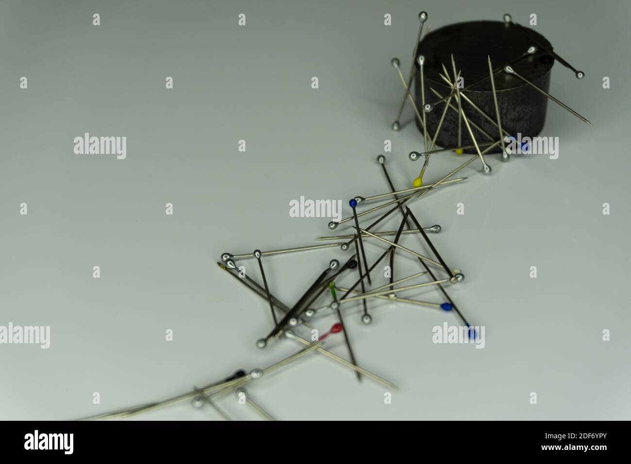 needles and magnet on a white background Stock Photo - Alamy