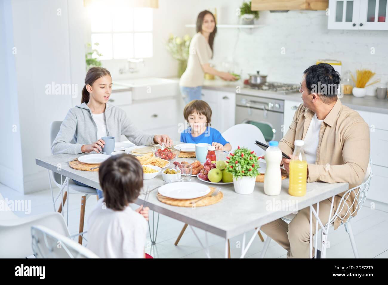 Latin family having dinner together at home. Woman serving a meal for ...