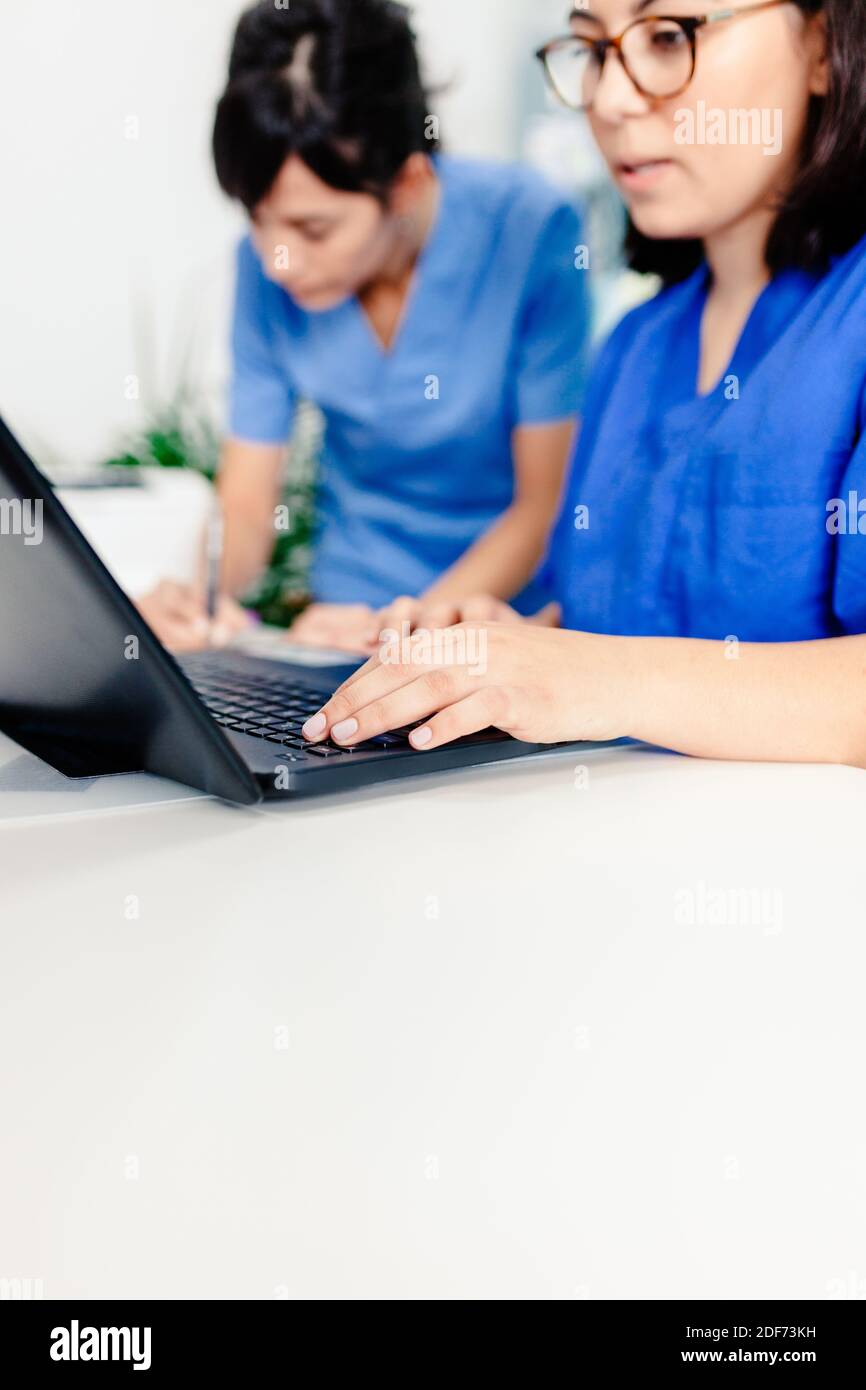 Female doctor and nurse using the laptop in the clinic Stock Photo - Alamy