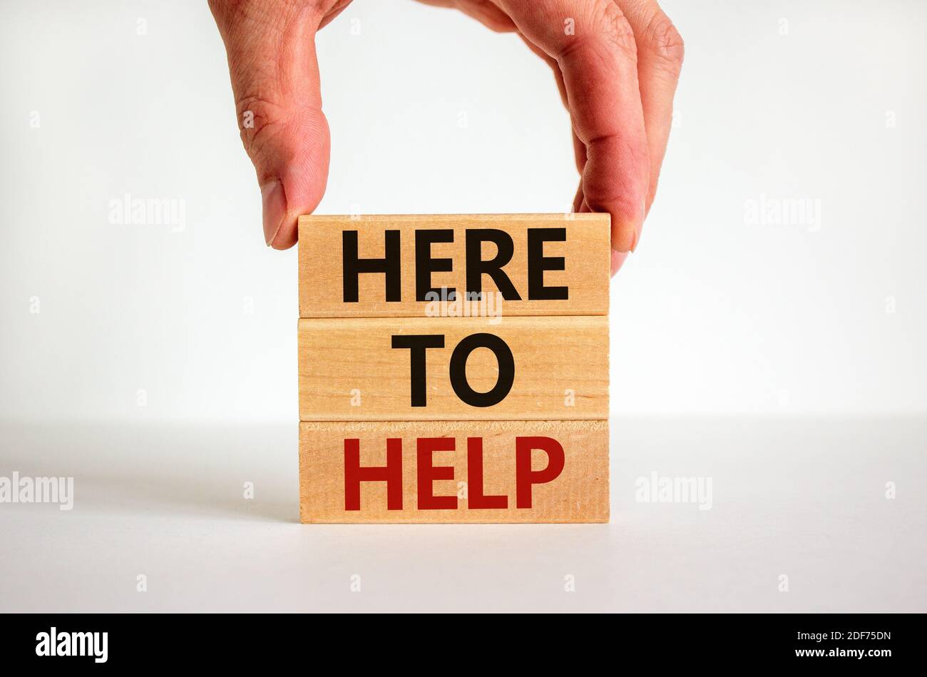 Here to help symbol. Male hand builds stack from blocks with words ...