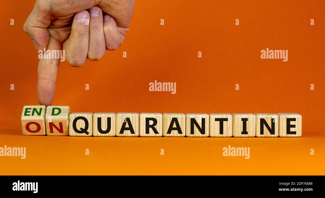 End quarantine symbol. Male hand turns cubes and changes the words 'on ...
