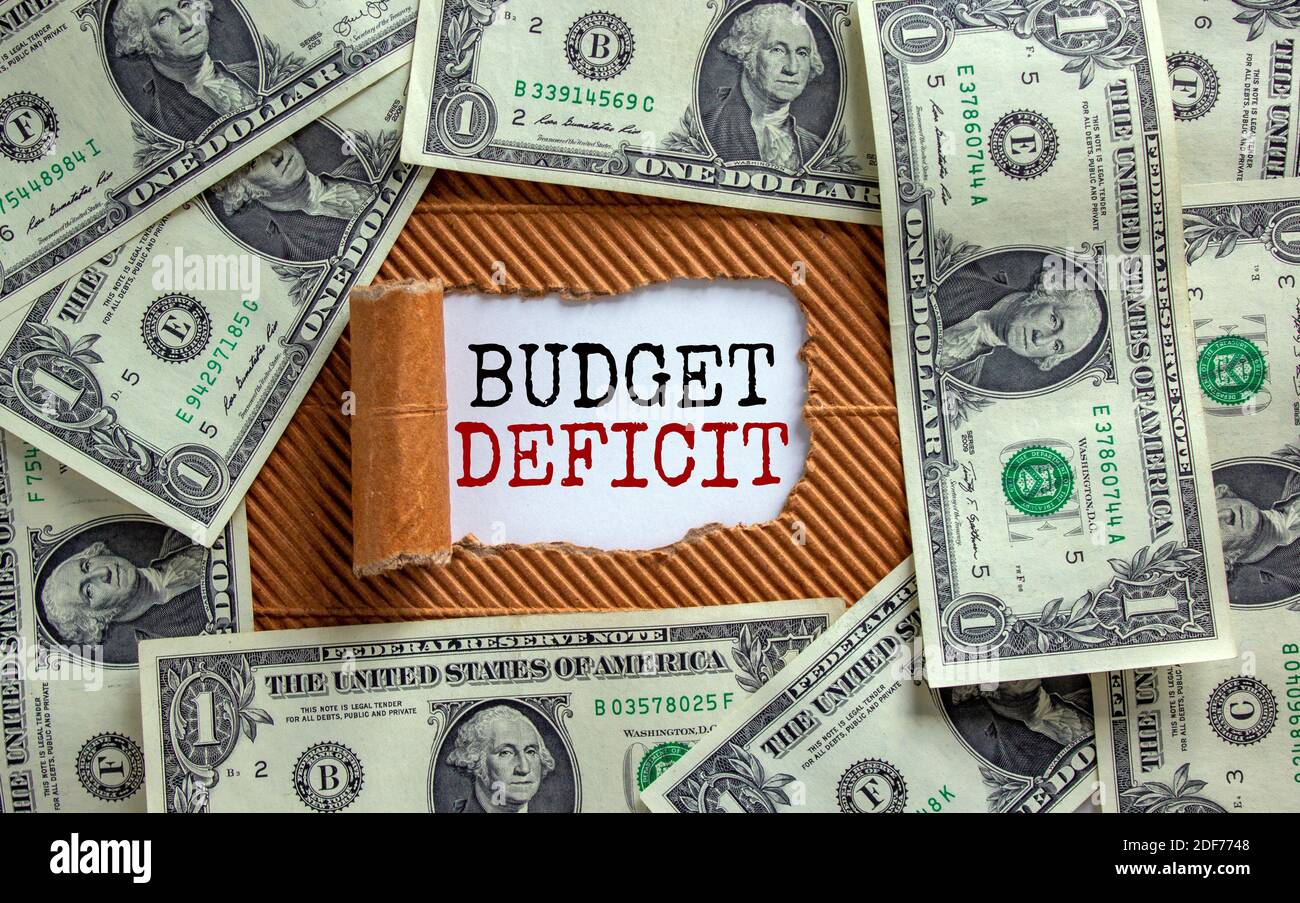 Budget deficit symbol. The words 'budget deficit' appearing behind torn ...