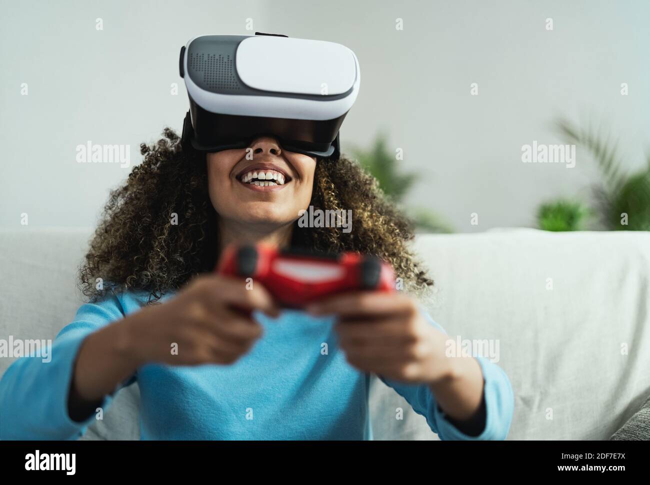 Young African woman playing online video games - Happy gamer having fun ...