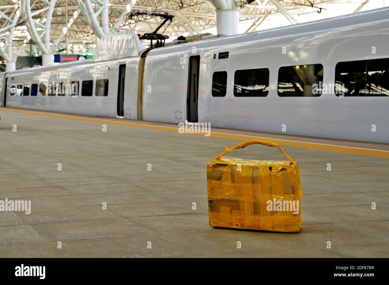 Abandoned self made carton suitcase laying on railway station quay ...
