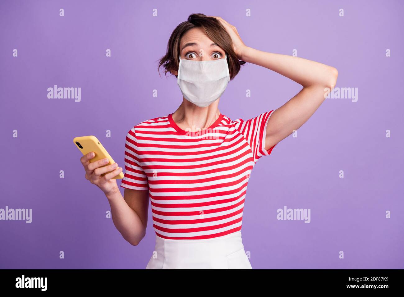 Photo of amazed cute lady hold smartphone hand head wear medical mask ...