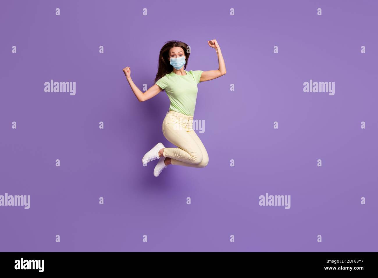 Full length view of girl jumping having fun wear mask isolated bright ...