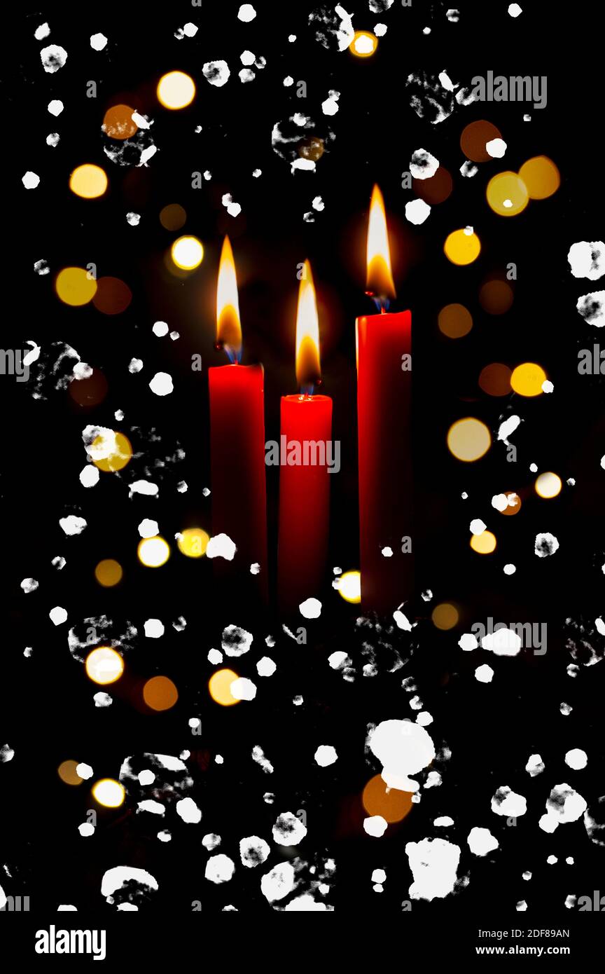 Three red lit candles with colorful bokeh background of spots and snow ...