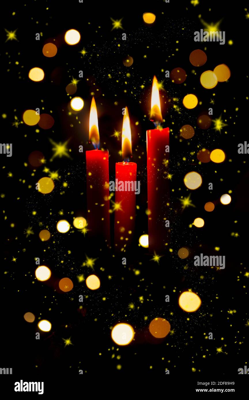 Three red lit candles with colorful bokeh background of spots and stars ...