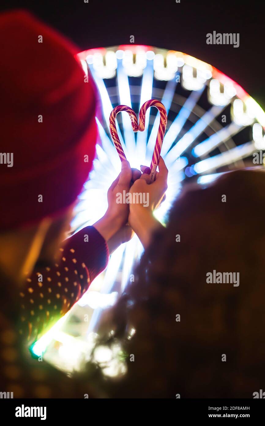 Candy canes in the shape of heart on the background of the ferris wheel ...