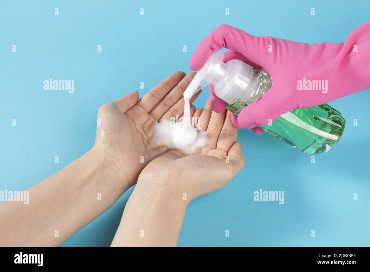 A top view closeup of a hand wearing gloves spraying a sanitizer to ...