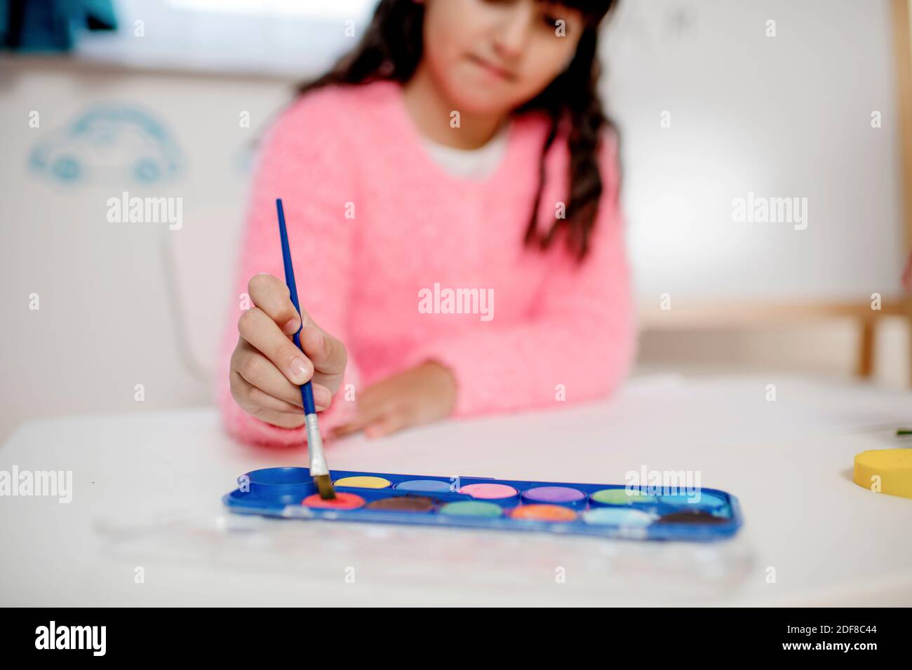 Cute little girl coloring with water colors Stock Photo - Alamy