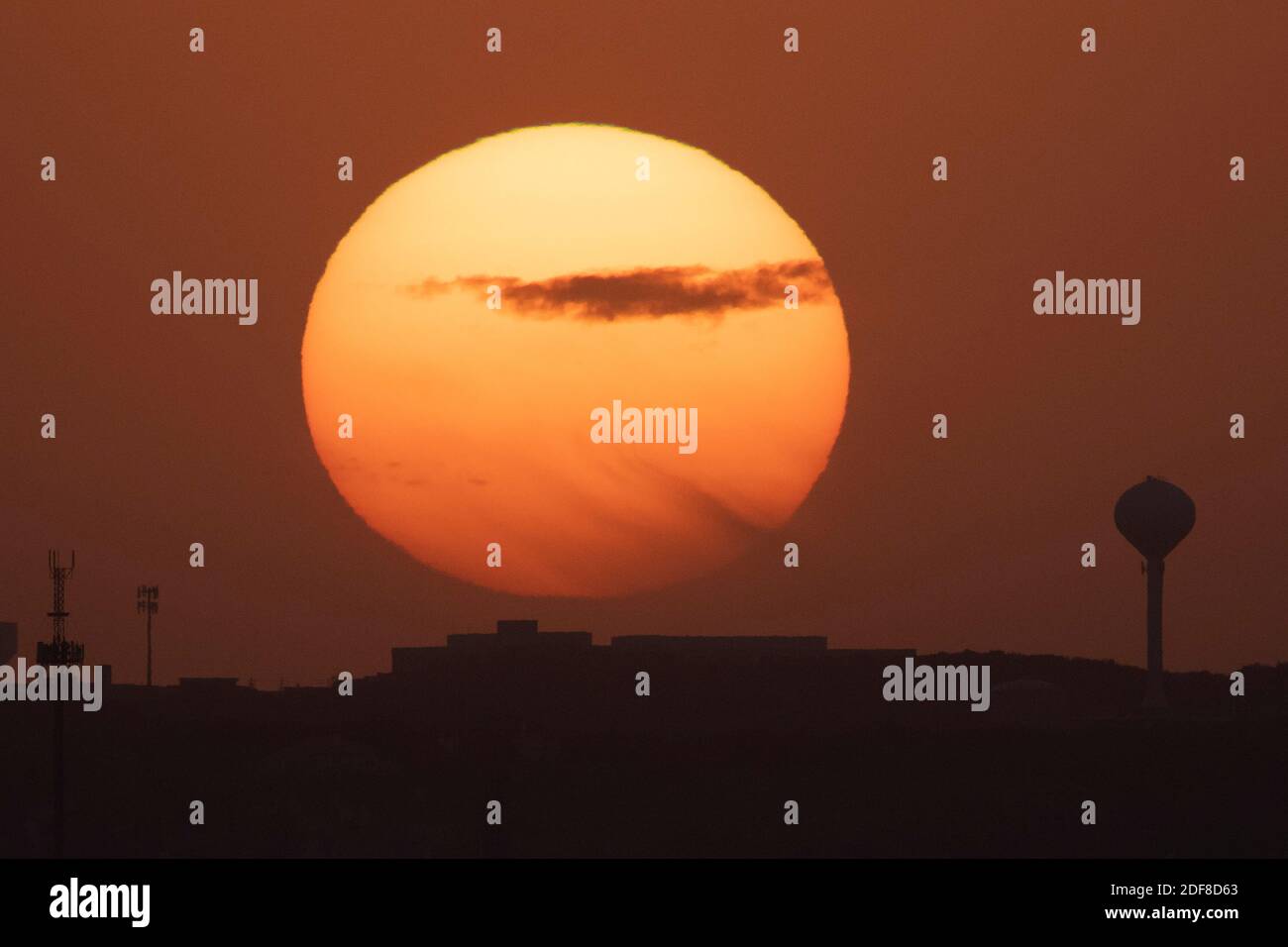 The setting sun descends over the horizon west of Austin as ...