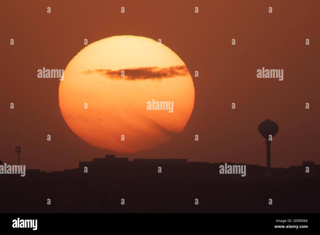 The setting sun descends over the horizon west of Austin as ...