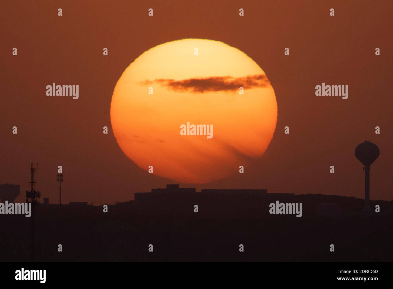 The setting sun descends over the horizon west of Austin as ...