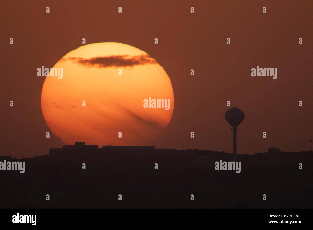 The setting sun descends over the horizon west of Austin as ...