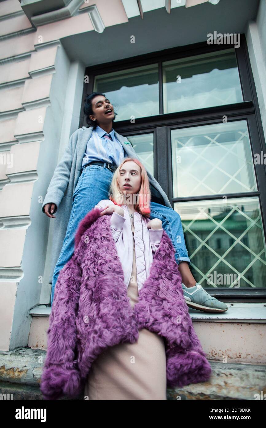 Two teenage girls infront of university building smiling, having fun ...