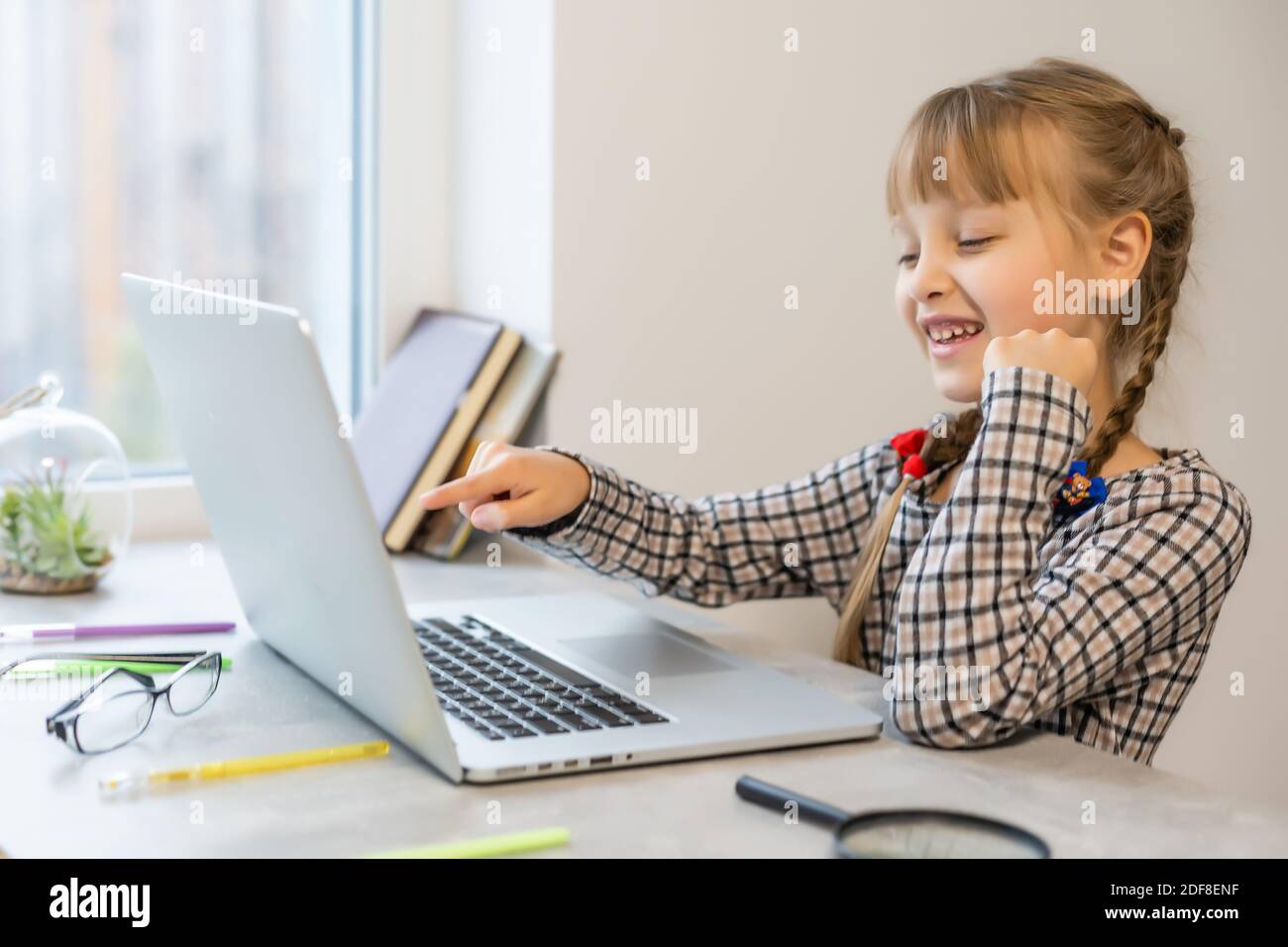 Little girl doing her homework at home and using a laptop Stock Photo ...