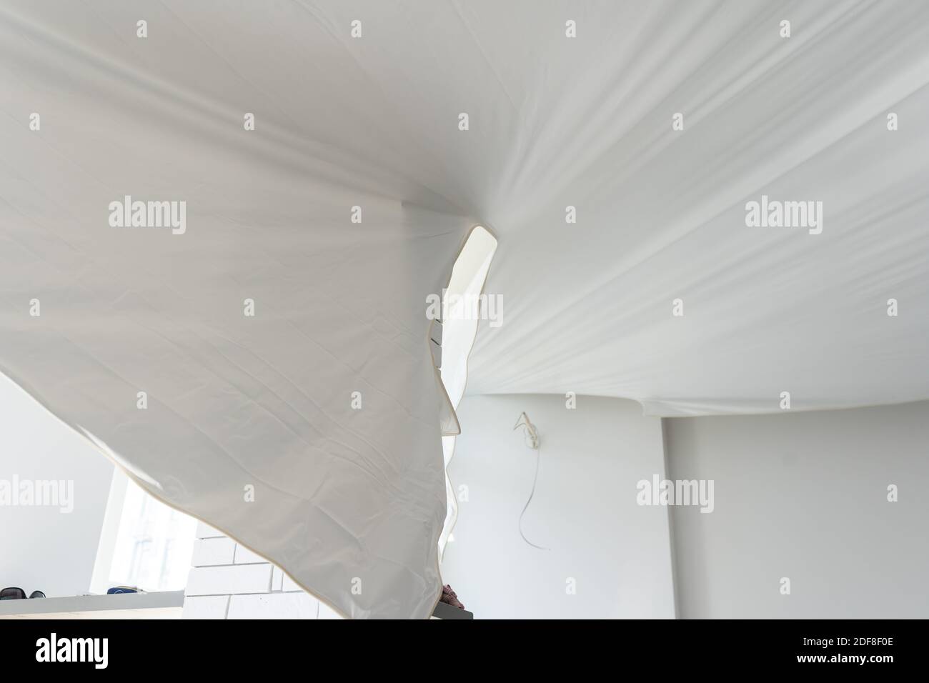 Stretch ceiling. Workers stretch the suspended ceiling in the room ...