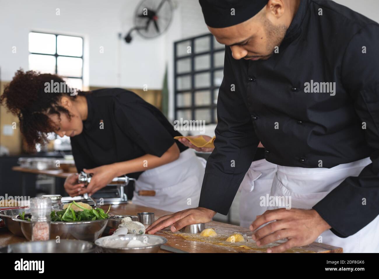 Male middle eastern chef cutting individual ravioli with stuffing at ...