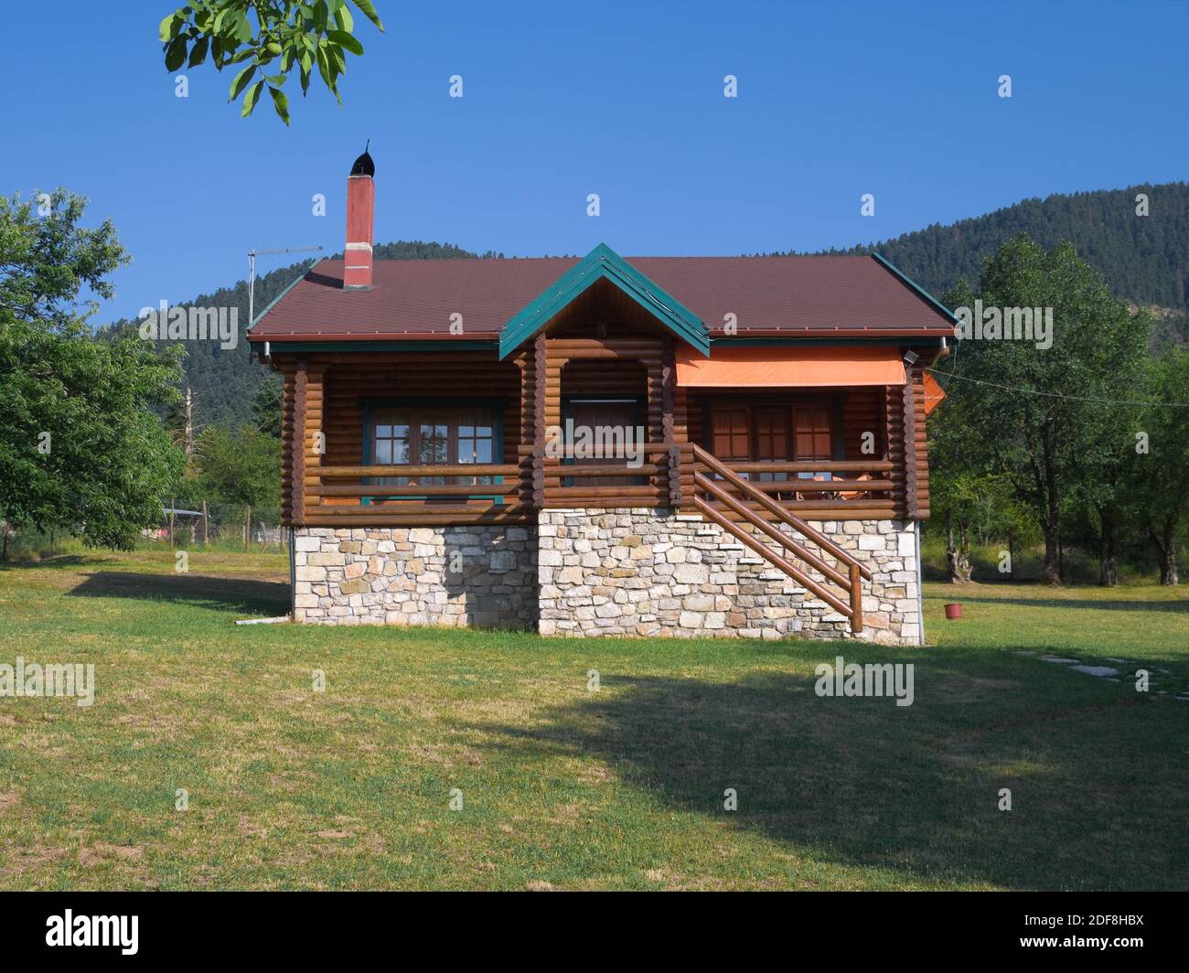 traditional chalet wooden and stone with green grass Stock Photo - Alamy