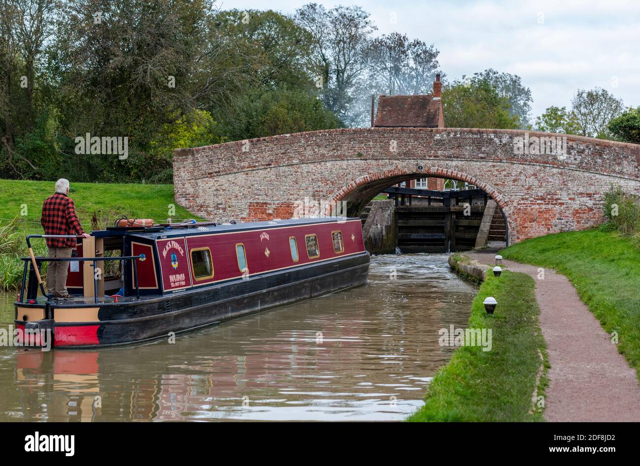 a narrow boat on the grand union canal approaching a bridge before ...