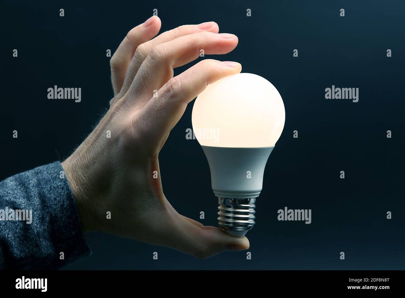 human hand holding the included led lamp on a dark background Stock ...