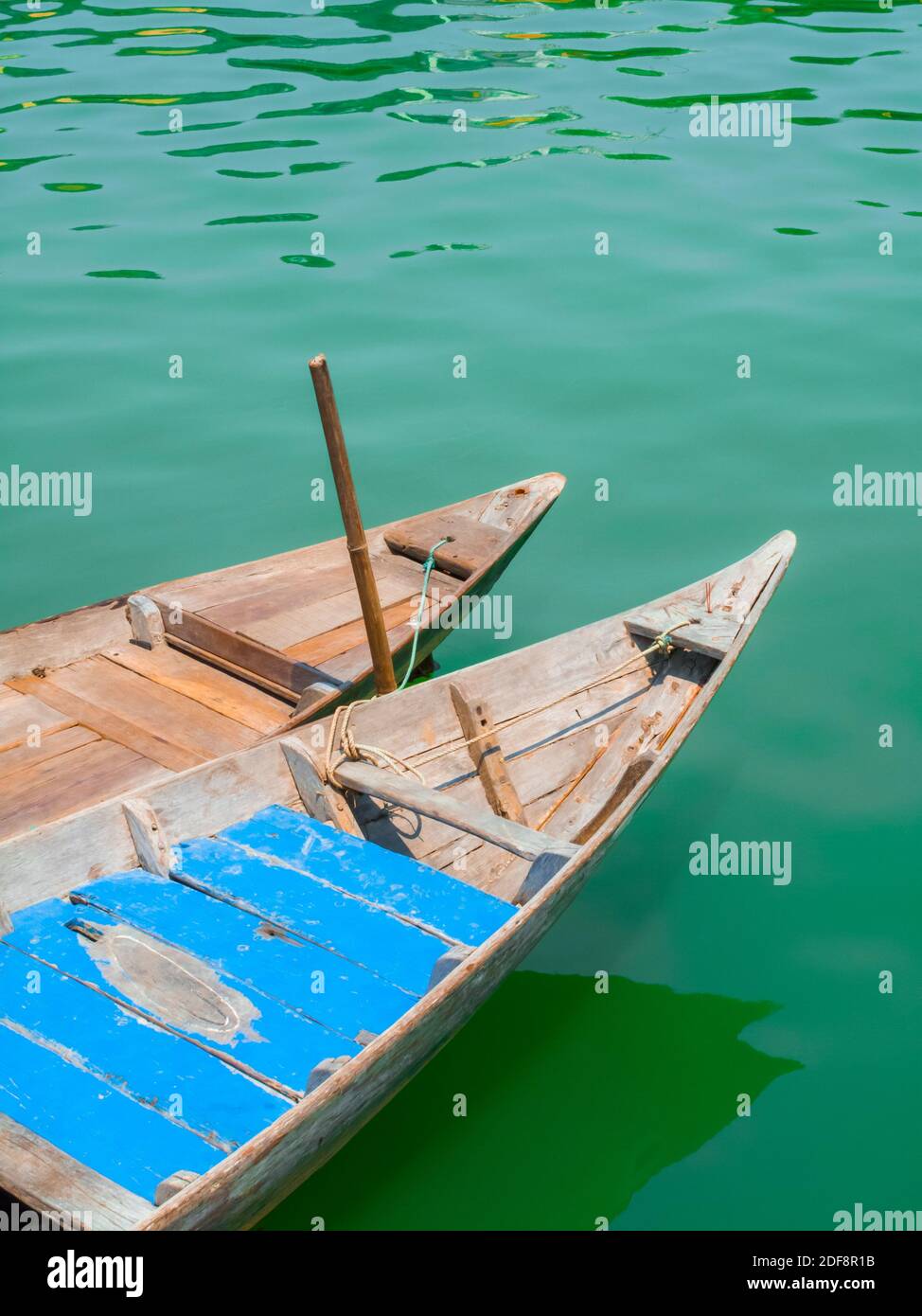 Pair of traditional wooden Vietnamese sampan rowboats on calm water ...