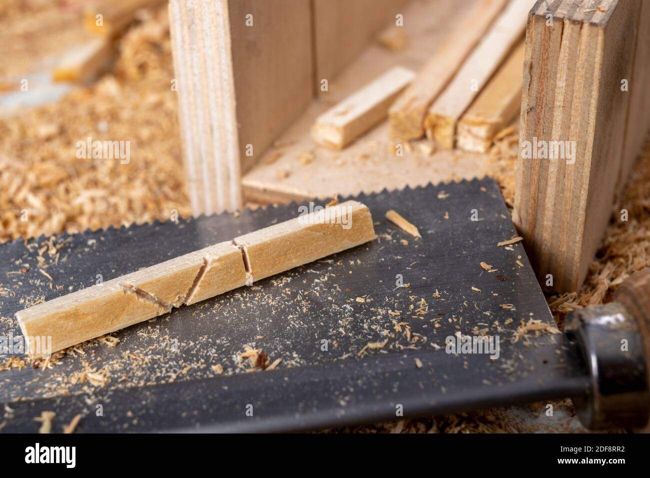 Cutting small pieces of wood with a saw in a carpentry shop. Minor ...