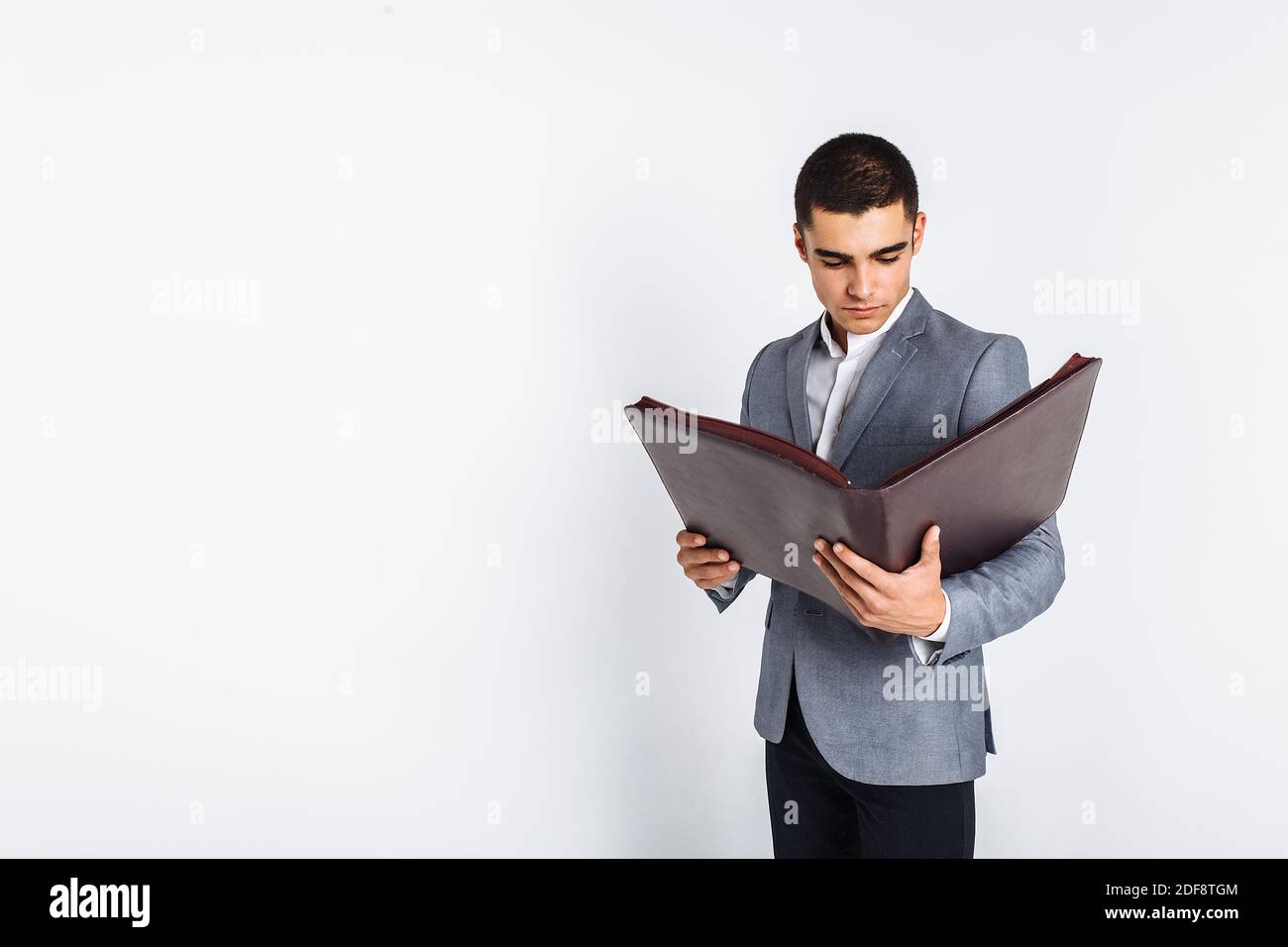 Handsome man with folder man reading a menu, a stylish business guy in ...