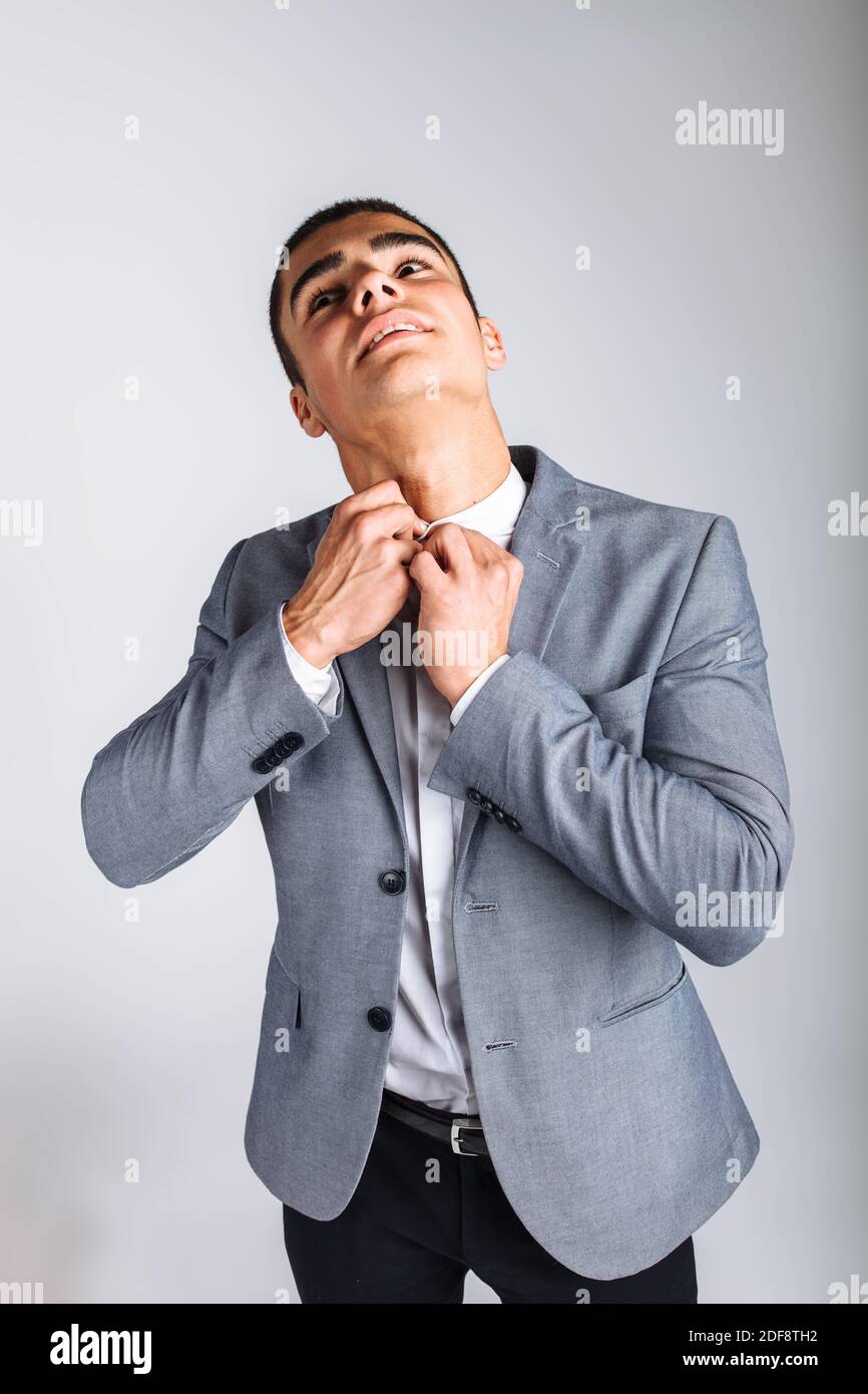 Stylish guy buttoning a button in Studio isolated background Stock ...