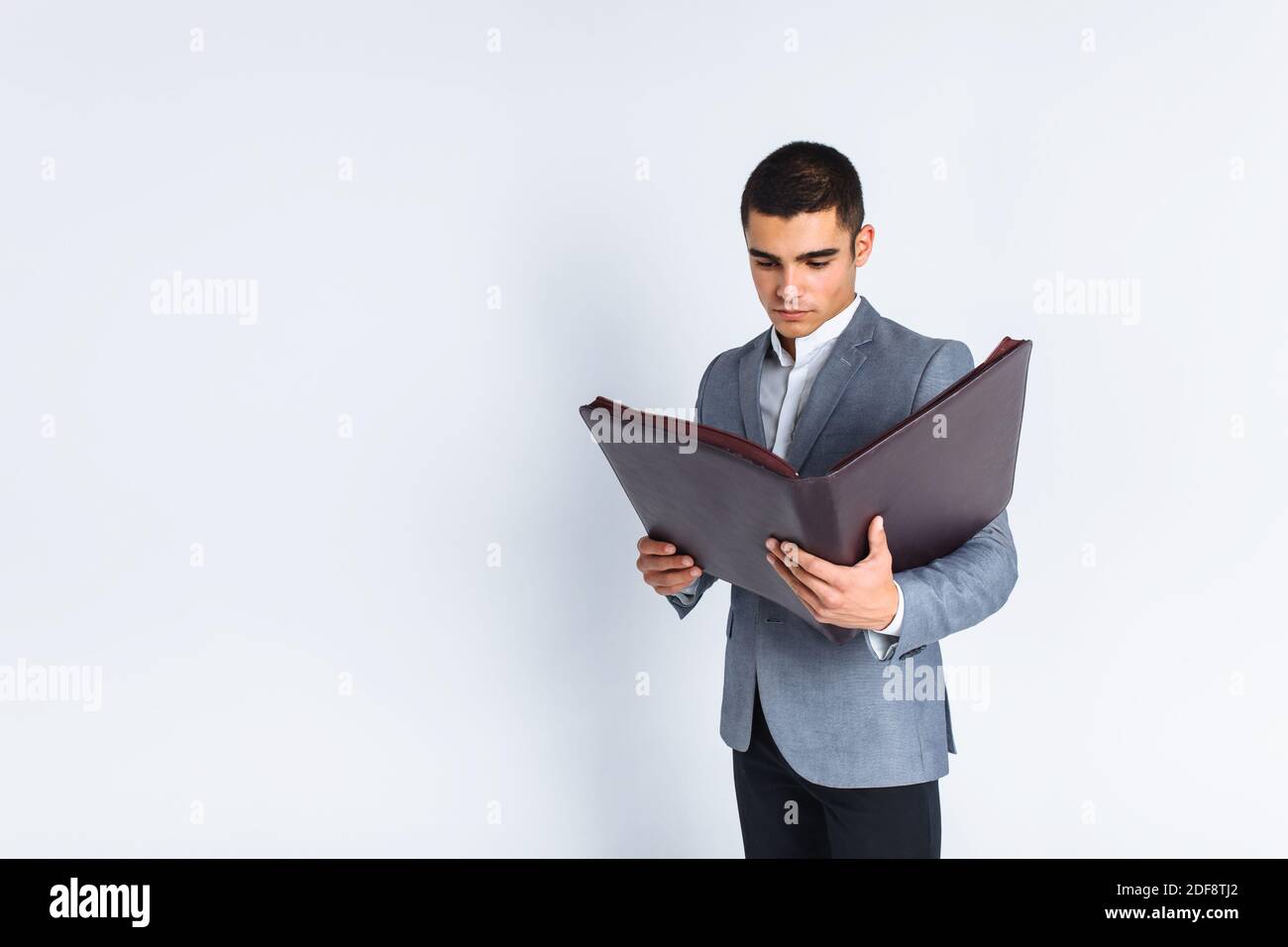 Handsome man with folder man reading a menu, a stylish business guy in ...
