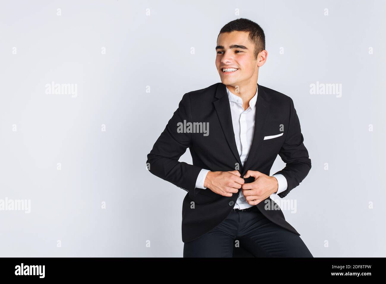 Stylish guy buttoning a button in Studio isolated background Stock ...