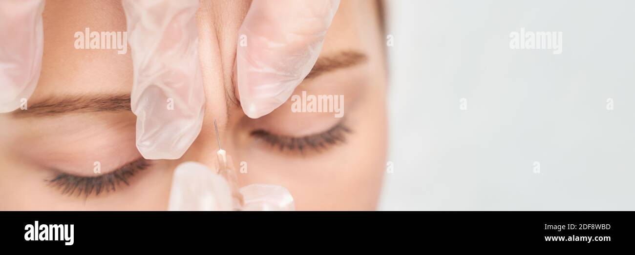 Forehead injection at spa salon. Doctor hands. Pretty female patient ...