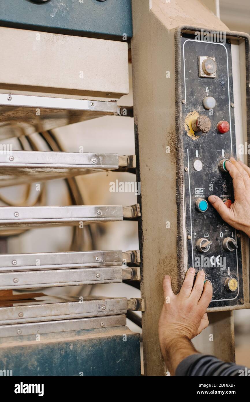 A vertical closeup shot of hands working the buttons of an industrial ...