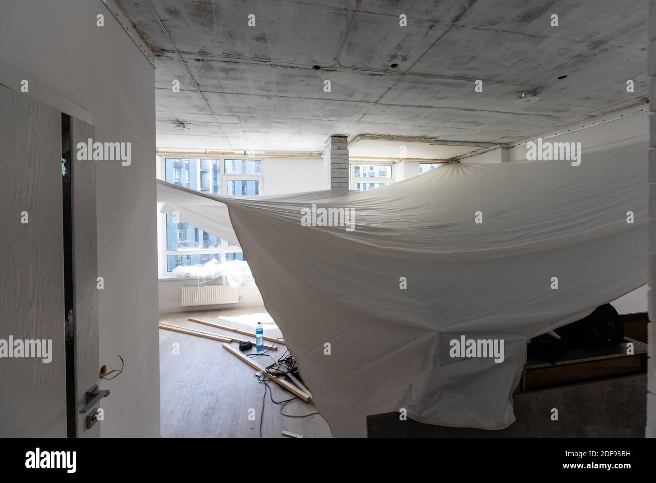 repairmen install stretch ceiling made of pvc vinyl film using a gas ...