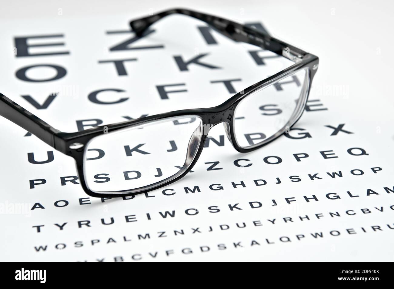 Eye test chart out of focus on white with glasses in foreground Stock ...