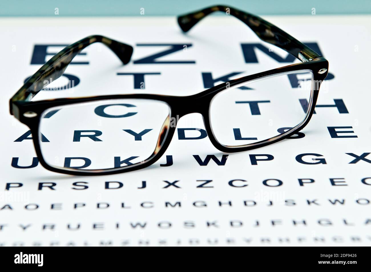 Eye test chart out of focus on white with glasses in foreground Stock ...