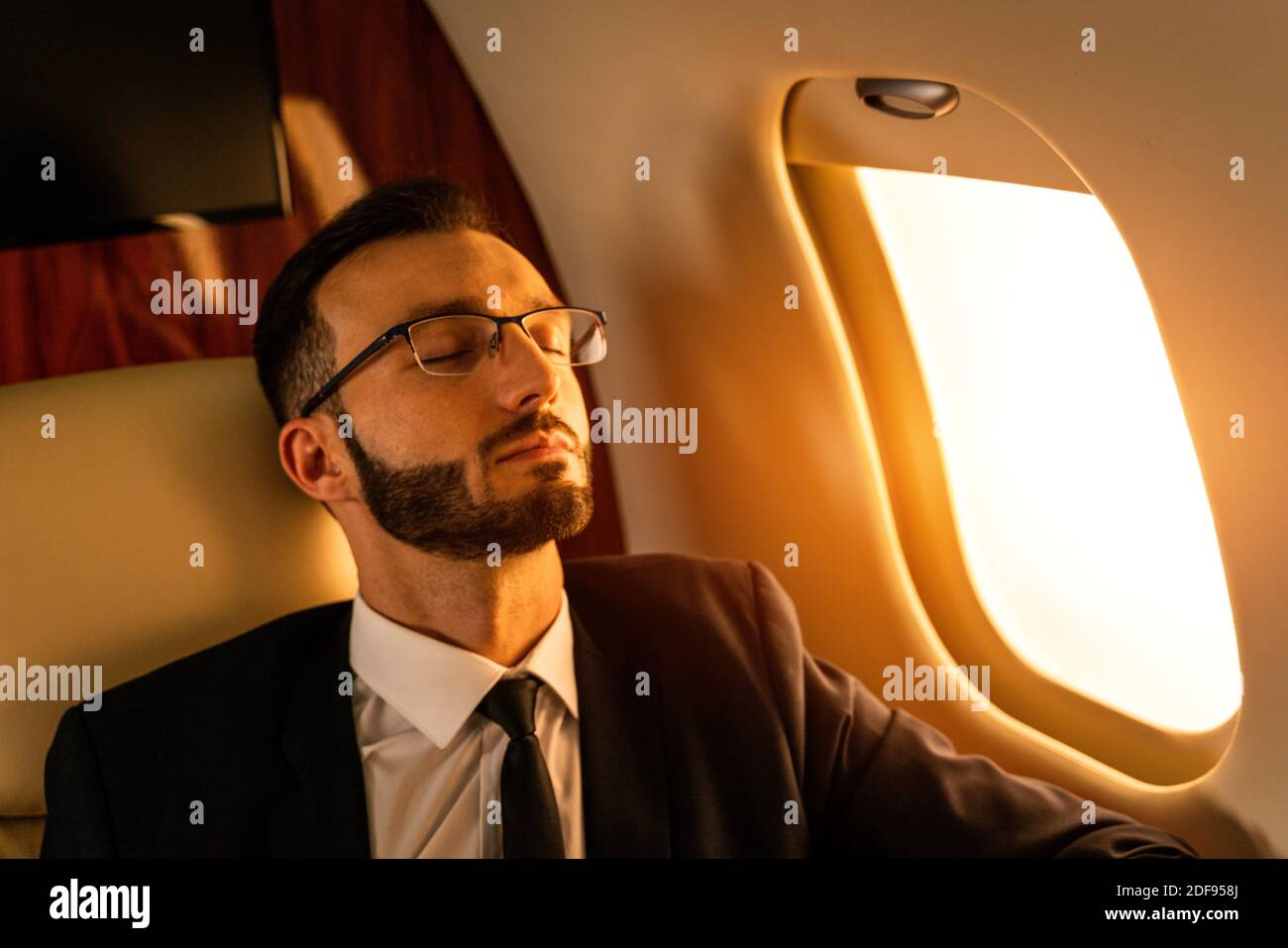 Handsome businessman wearing elegant suit flying on exclusive private ...